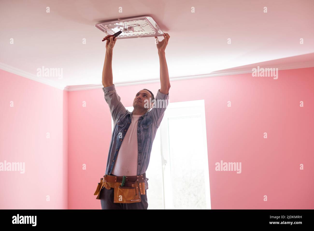 electrician installing a led light on the ceiling Stock Photo - Alamy