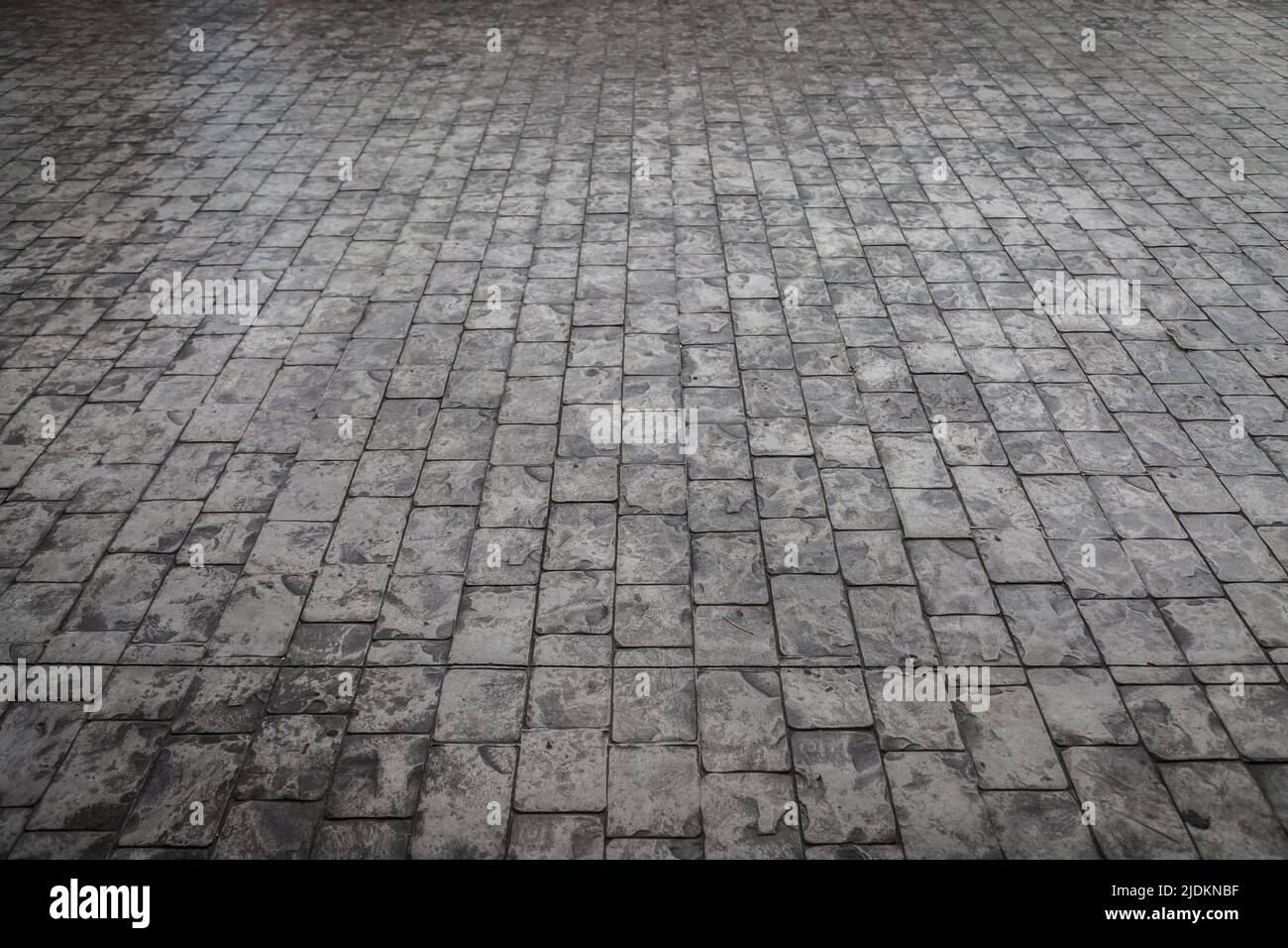 Road made of small pieces of old gray bright stone use for background ...