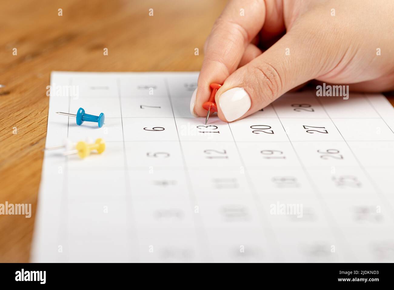 red Hand pin stuck on the day of the month in the calendar, business ...