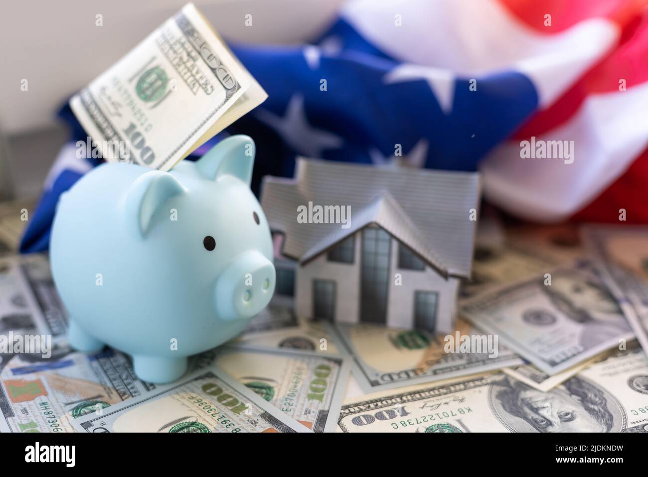 Small paper house and piggy bank on a pile of dollar banknotes, Money ...