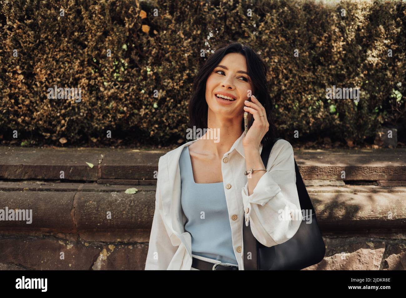 Cheerful Young Brunette Woman Making a Phone Call on Smartphone ...