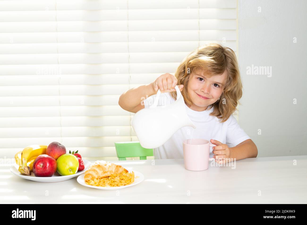 Fuuny little boy pouring whole cows milk for breakfast. Kid preteen boy ...