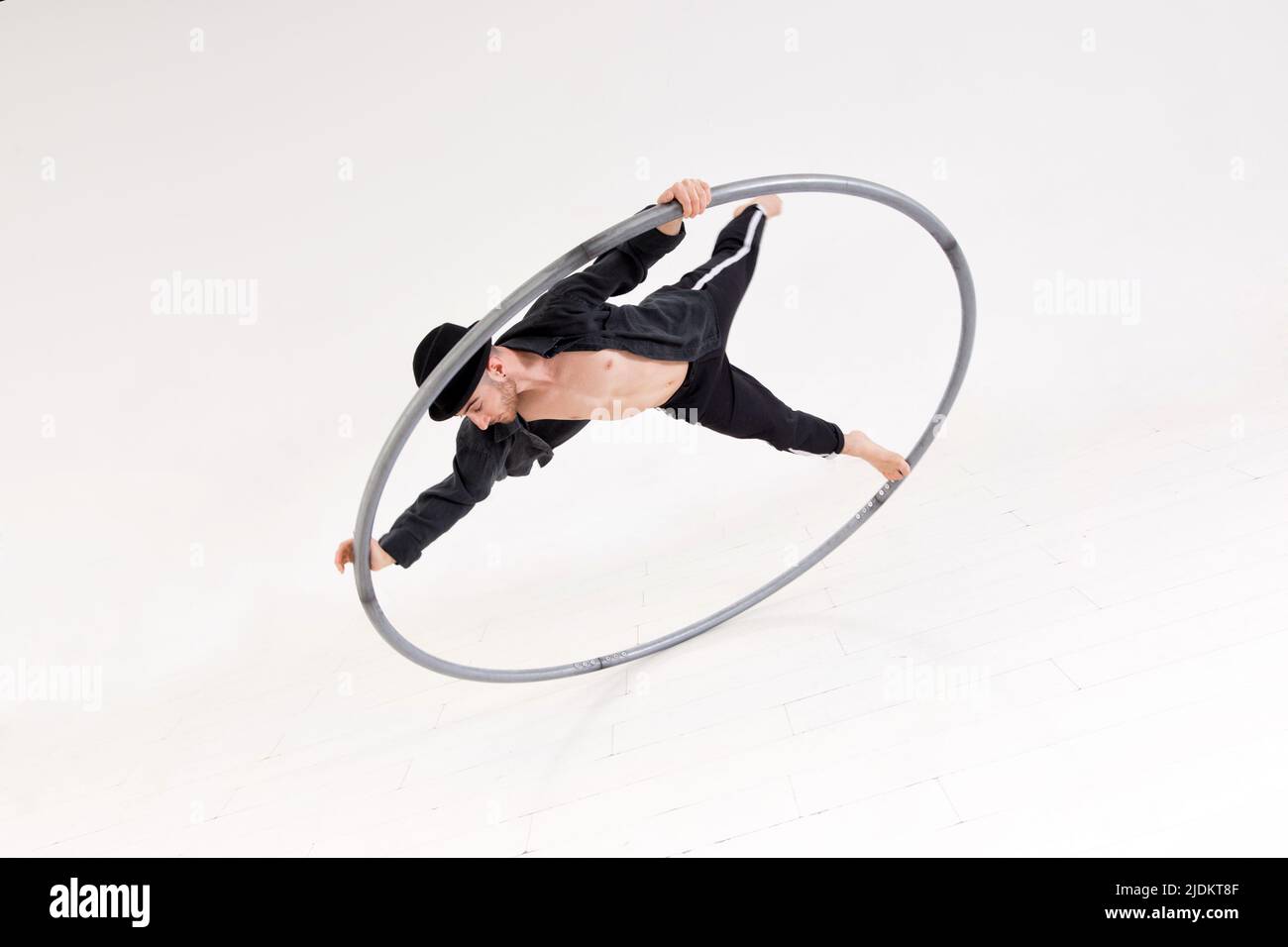 Acrobat performing a coin trick on a cyr wheel in spinning motion ...