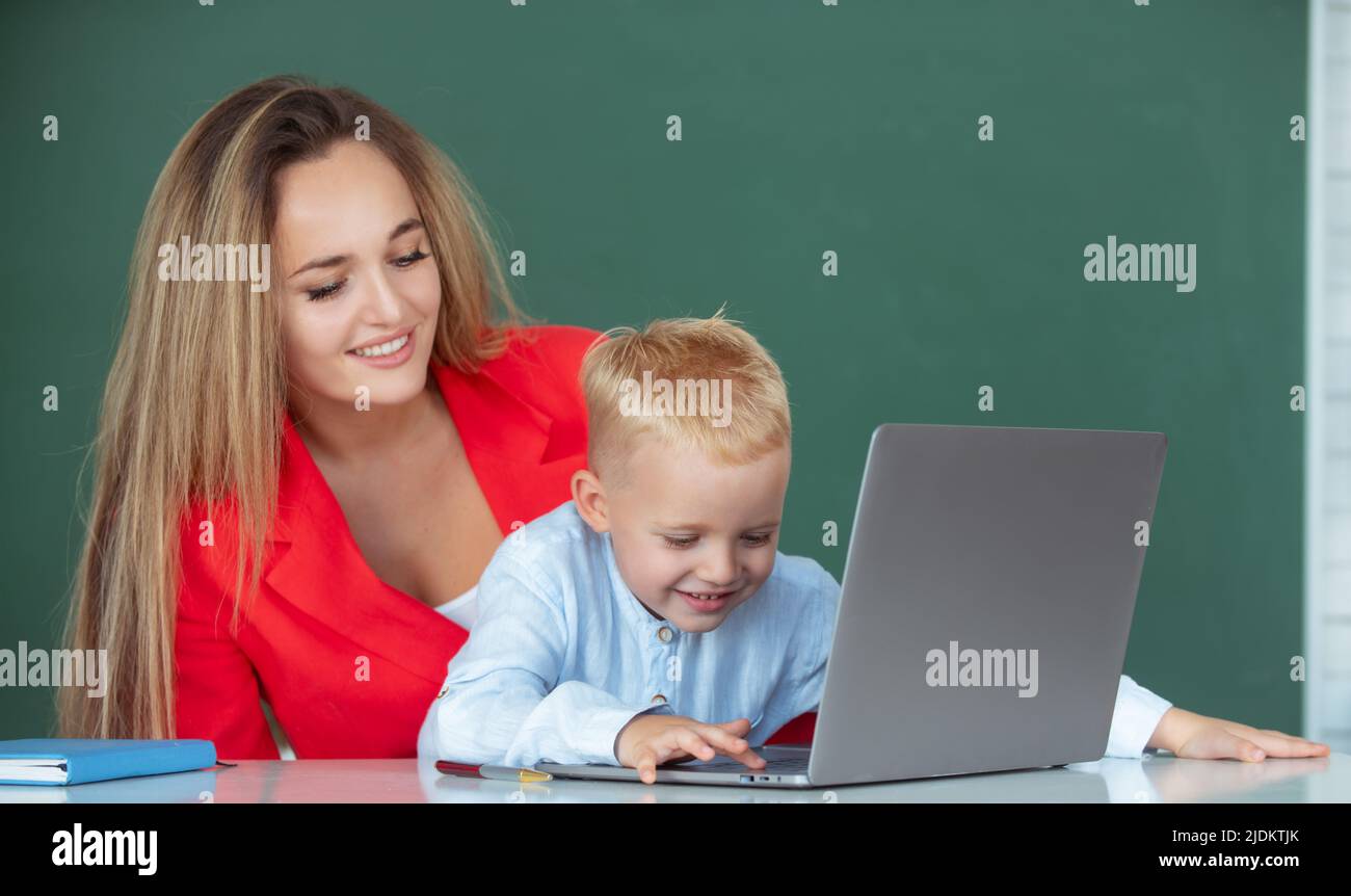 Mother and son together using computer laptop. Teacher explains lesson ...