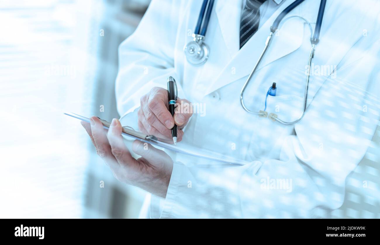 Doctor taking notes on clipboard in medical office; light effect Stock ...