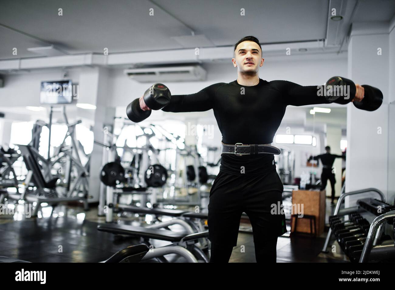 Muscular arab man training with dumbbells in modern gym Stock Photo - Alamy