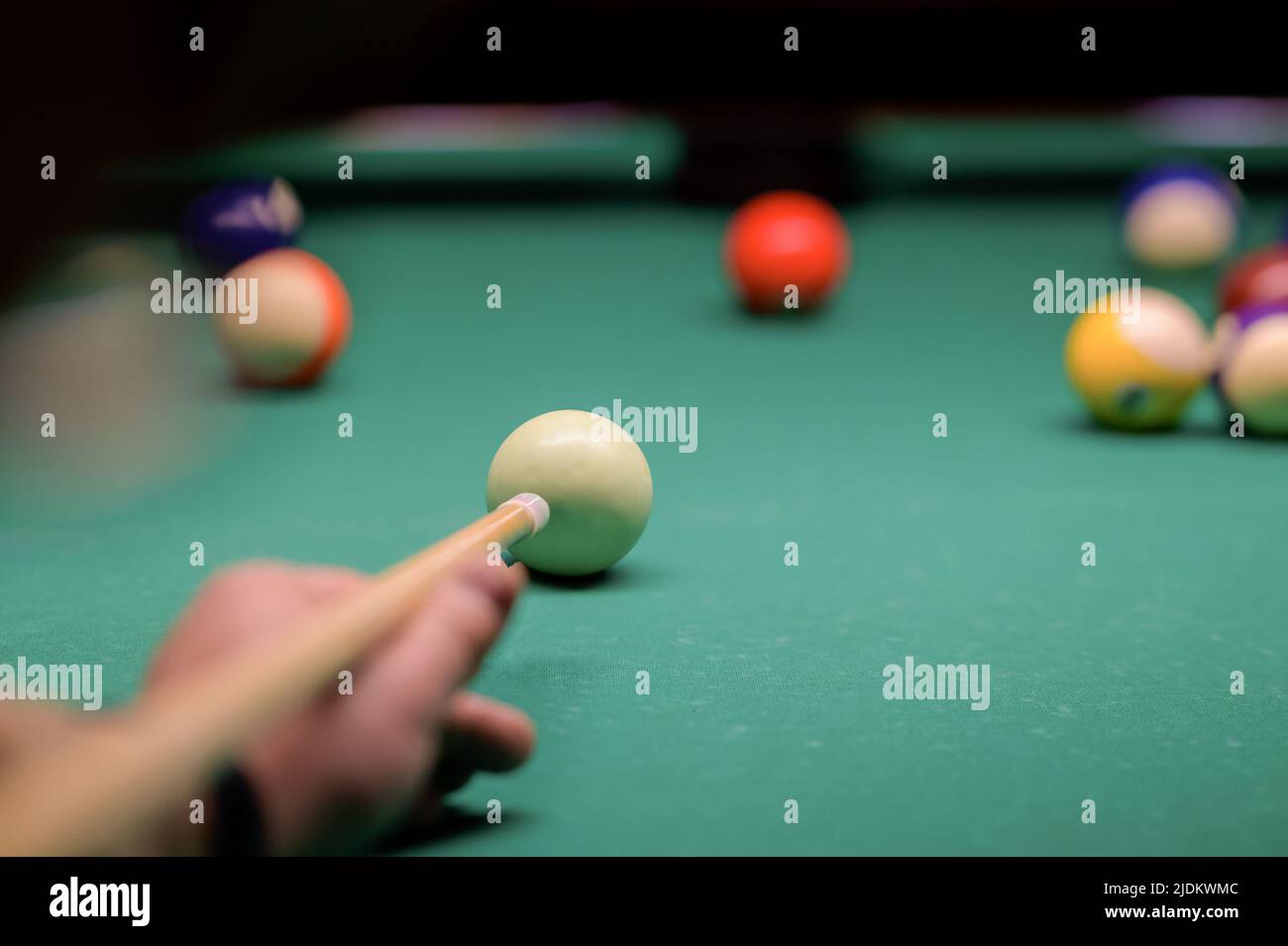 a man plays billiards in a bar. snooker, man aiming at the cue ball ...