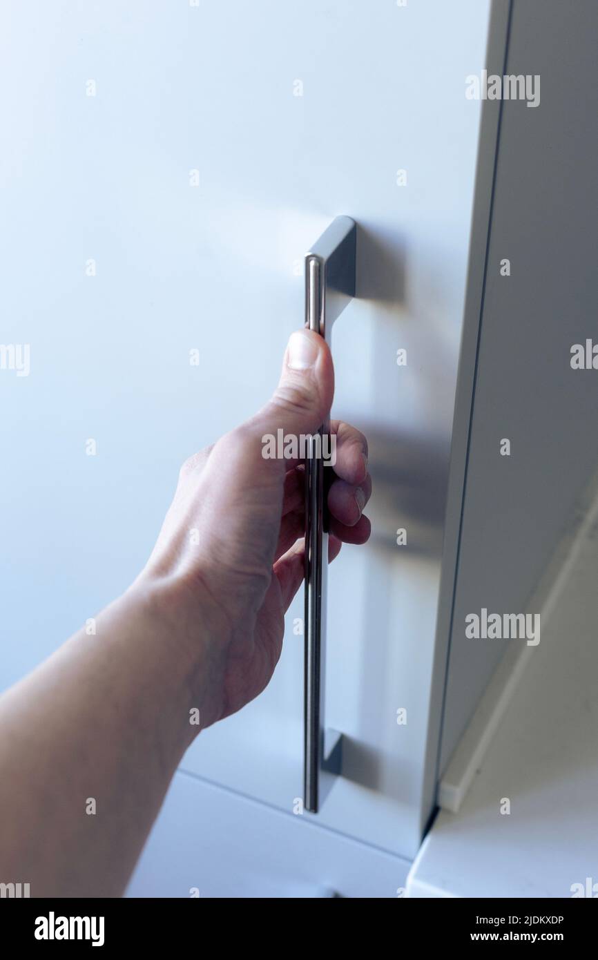A hand opening a closet door.Wardrobe for things Stock Photo - Alamy