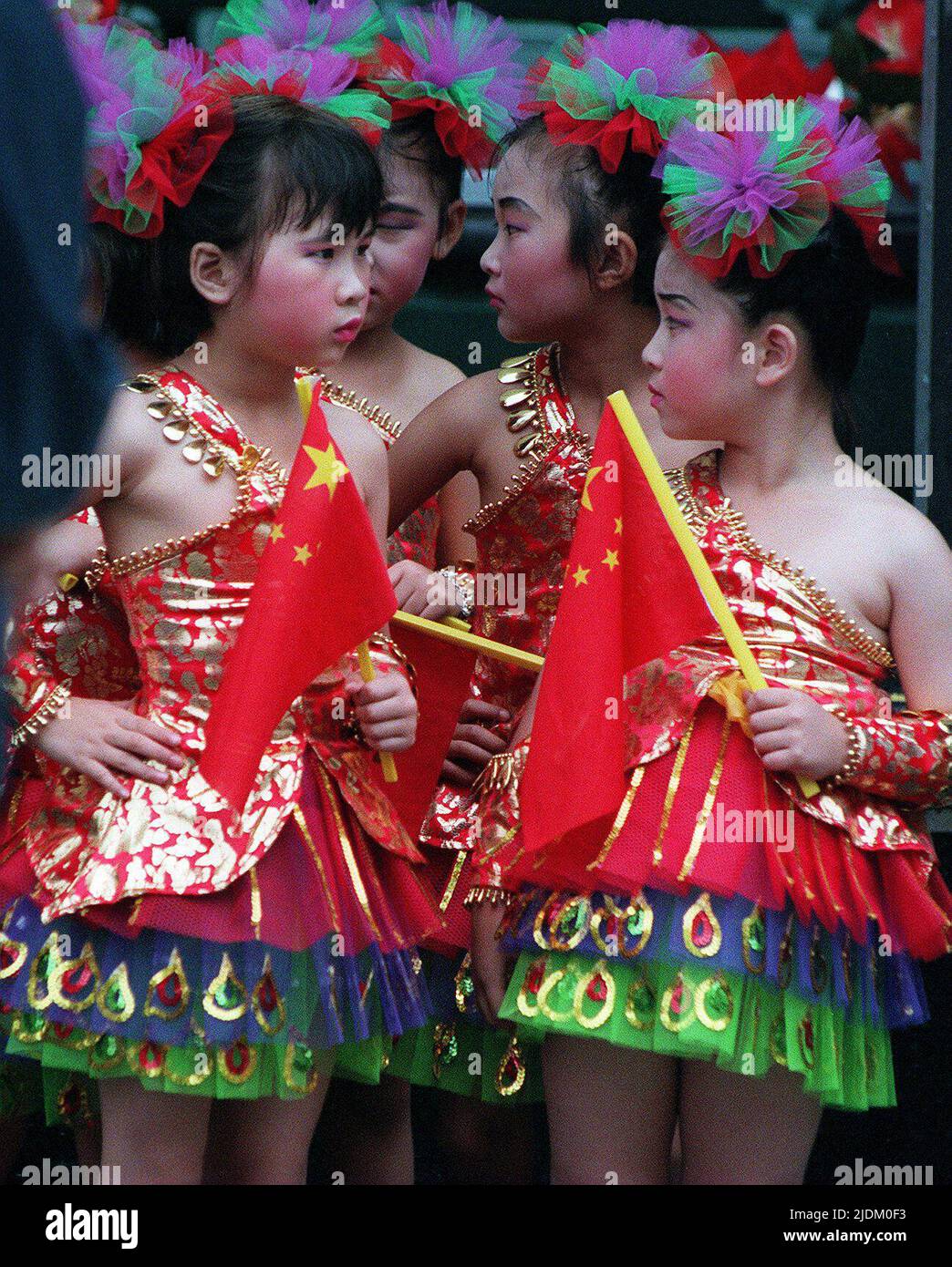 Pupils hold Chinese flags while waiting for their dancing performanace ...