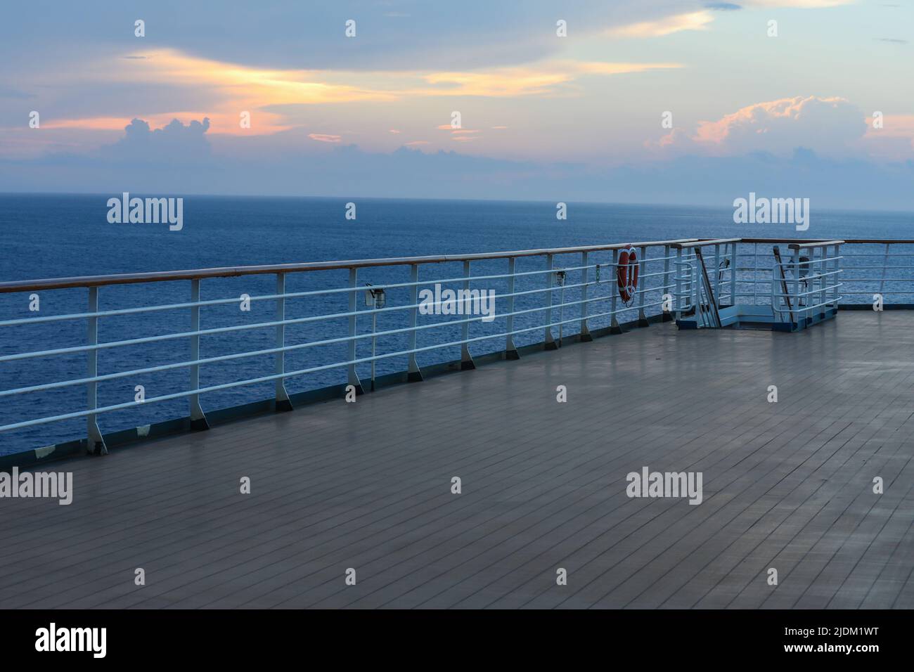 Wooden deck and railing from cruise ship. Beautiful sunset and ocean ...
