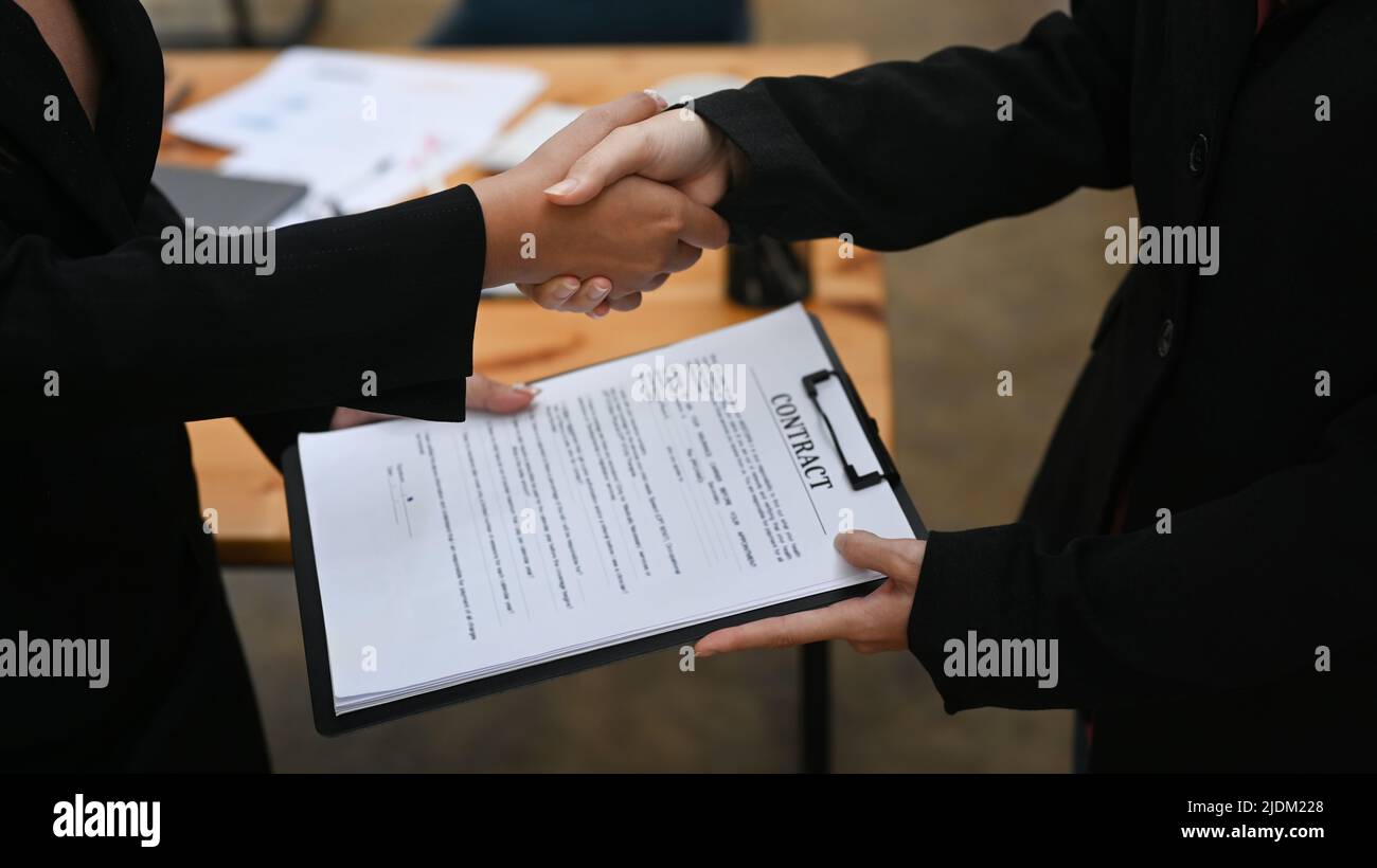 Successful business partner shaking hands after finishing up a meeting ...
