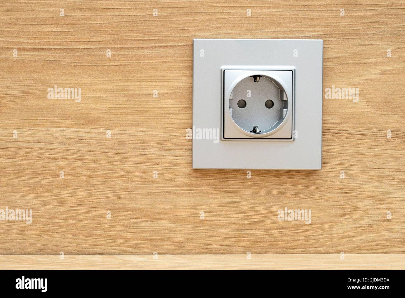 Close-up of silver plastic socket on the wooden wall above a desk Stock ...