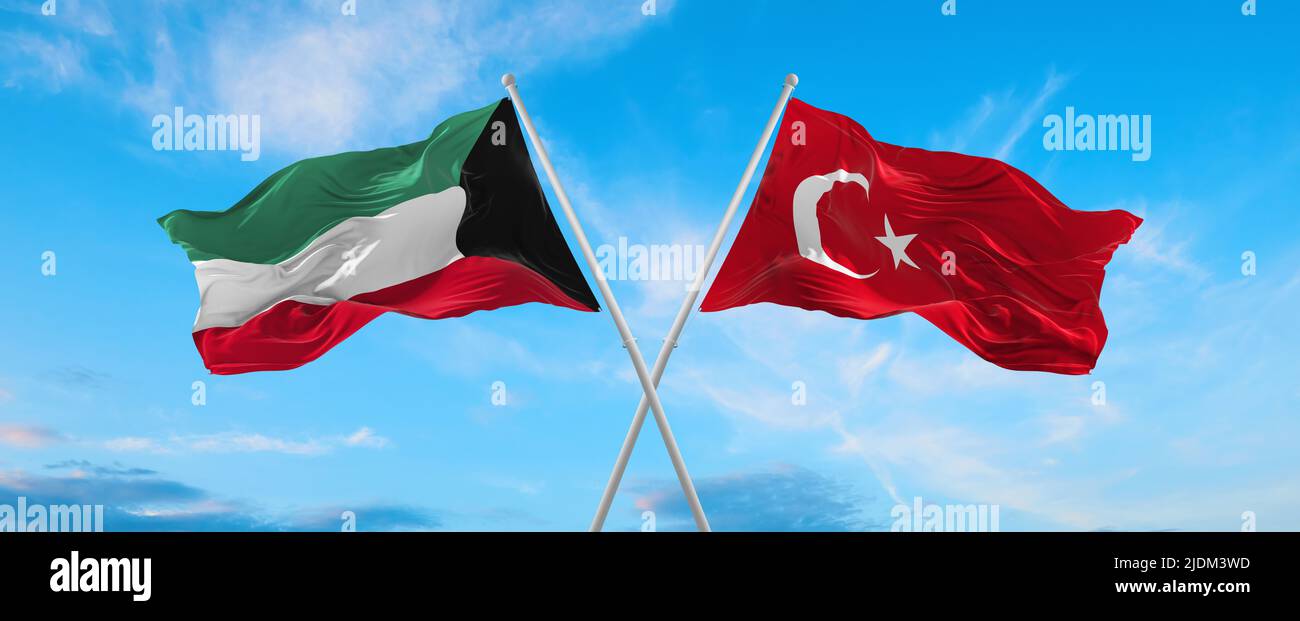 two crossed flags Kuwait and Turkey waving in wind at cloudy sky ...