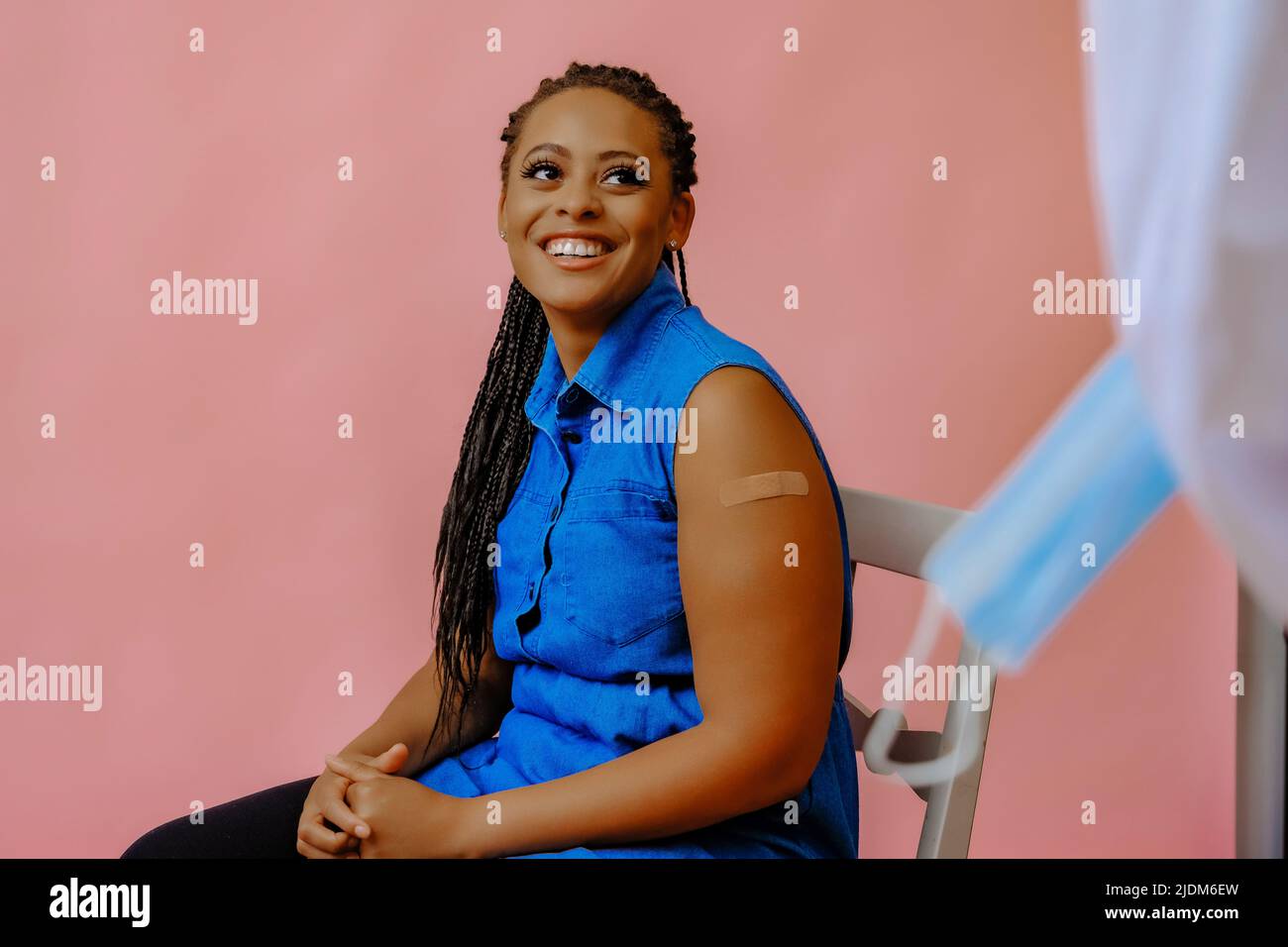 smiling black young adult woman with bandage plaster on arm sitting on ...