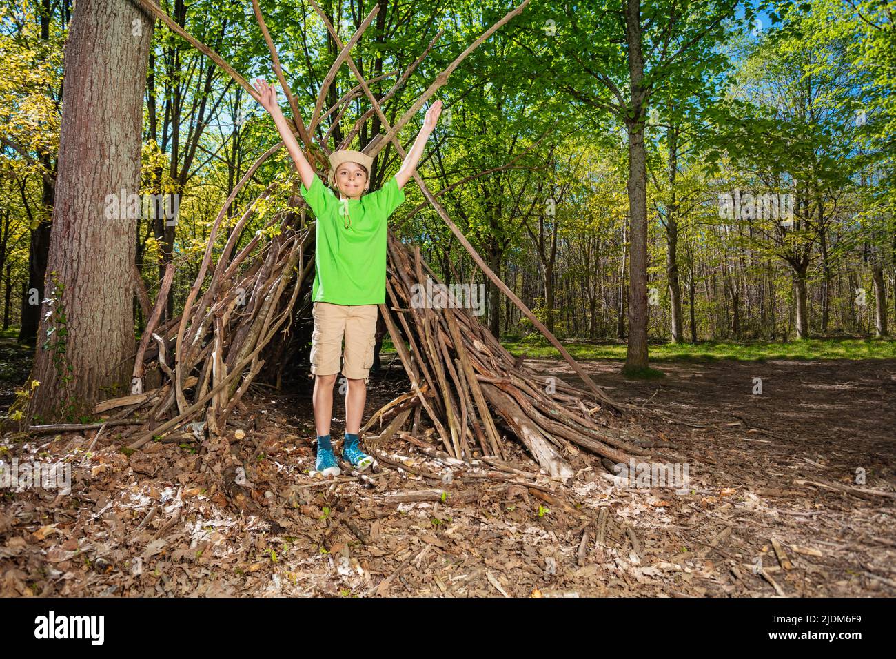 Child with boy-scout hat plain in the forest hut of branches Stock ...