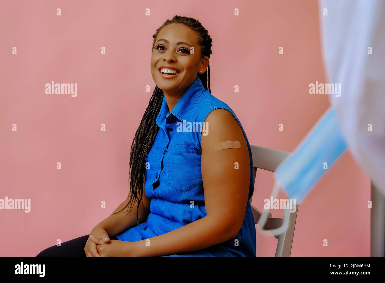 smiling black young adult woman with bandage plaster on arm sitting on ...