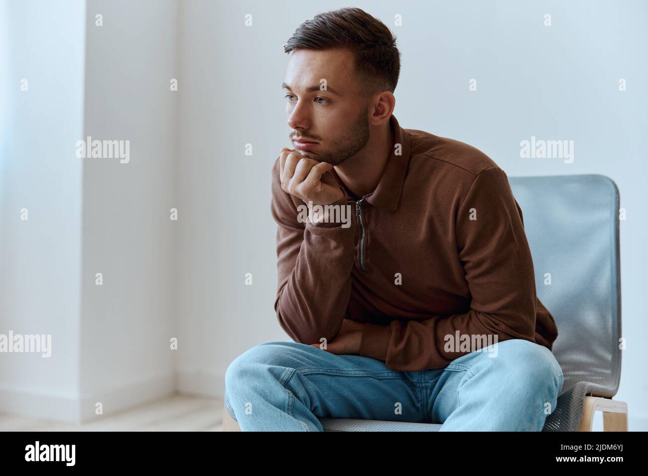 Upset frustrated thoughtful pensive serious young man reclines on hand ...