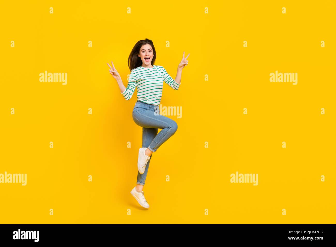 Full size photo of cheerful overjoyed female jumping showing v-sign say ...