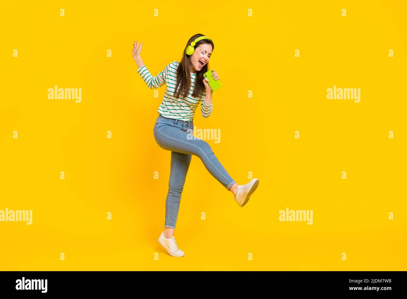 Full body image of overjoyed carefree female dancing singing her ...