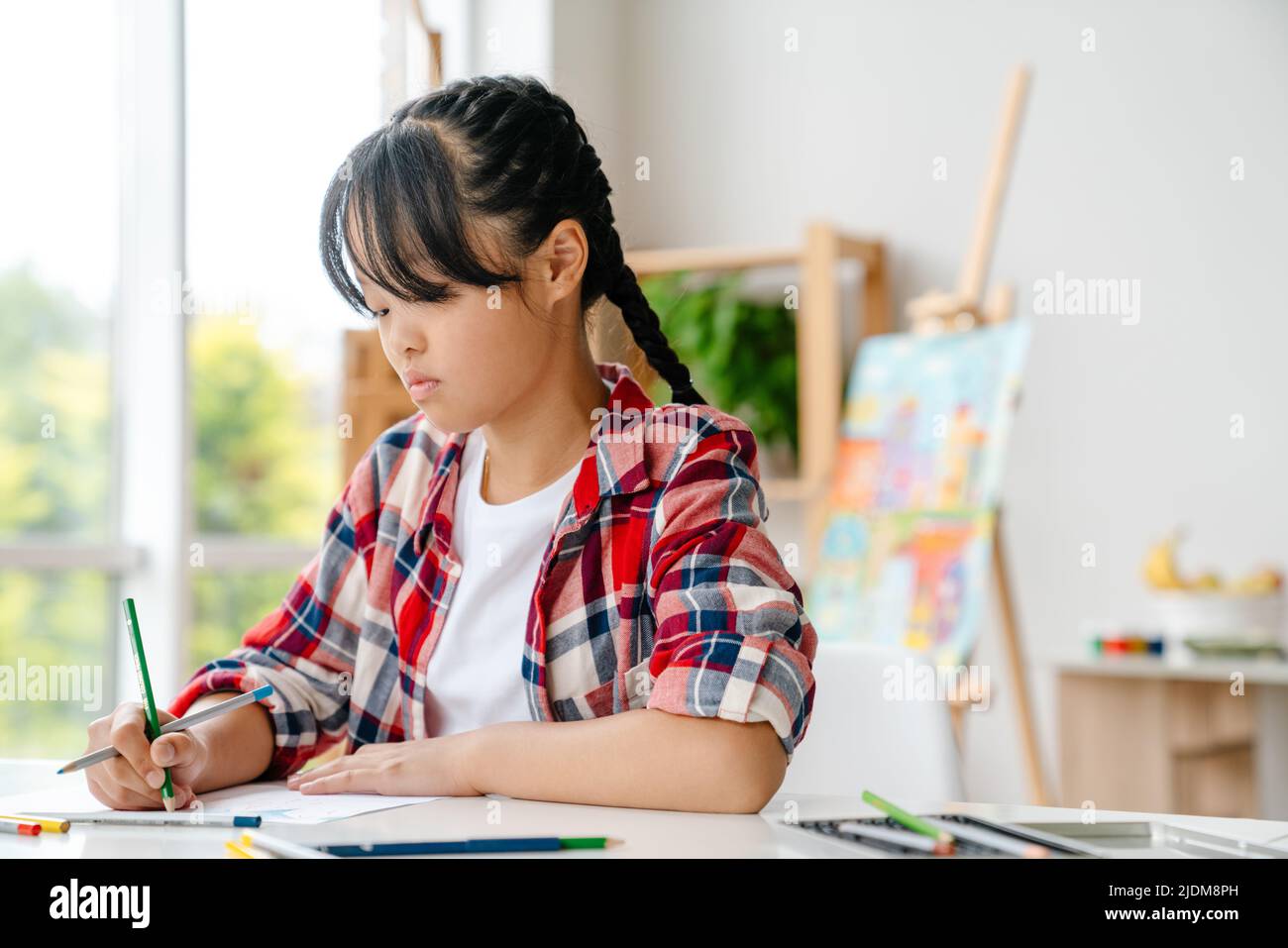 Asian girl drawing during class in art school indoors Stock Photo - Alamy