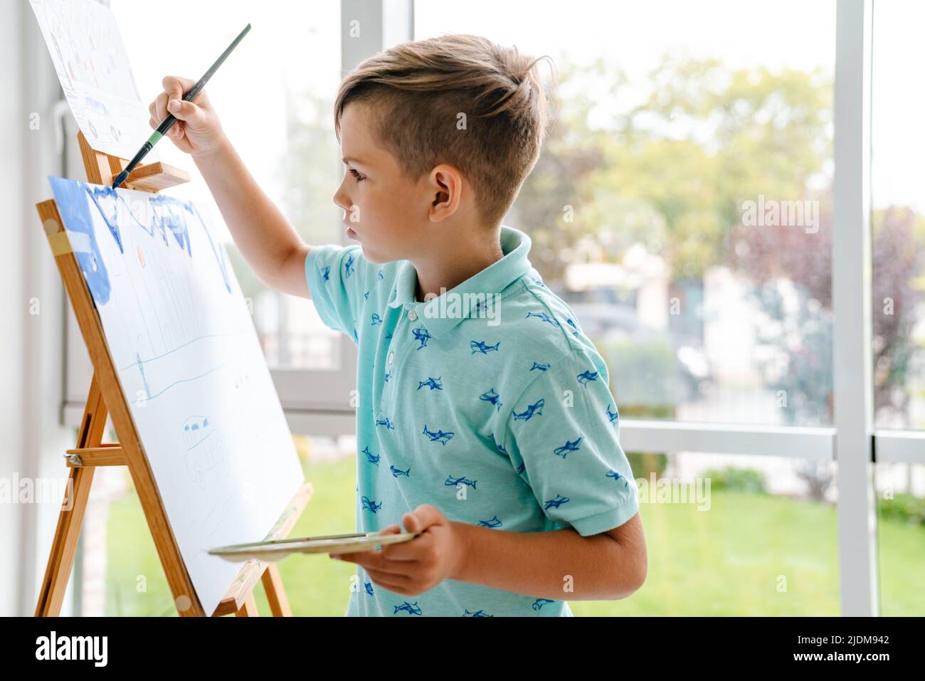 White blonde boy drawing during class in art school indoors Stock Photo ...