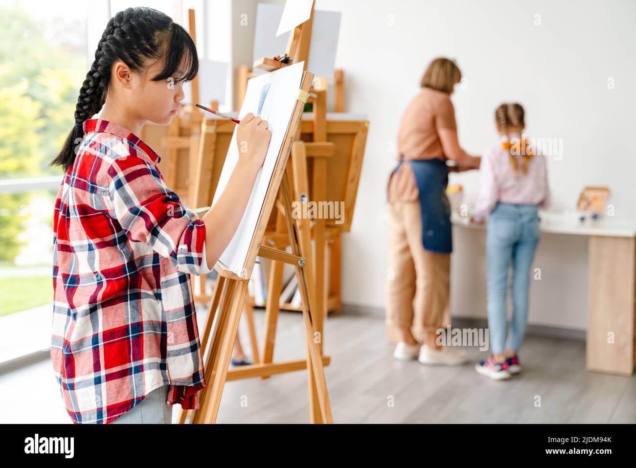 Asian girl drawing during class in art school indoors Stock Photo - Alamy