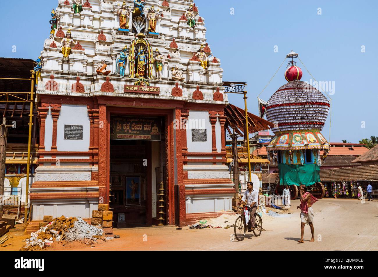 Udupi, Karnataka, India : A man cycles past the gopuram tower of the ...