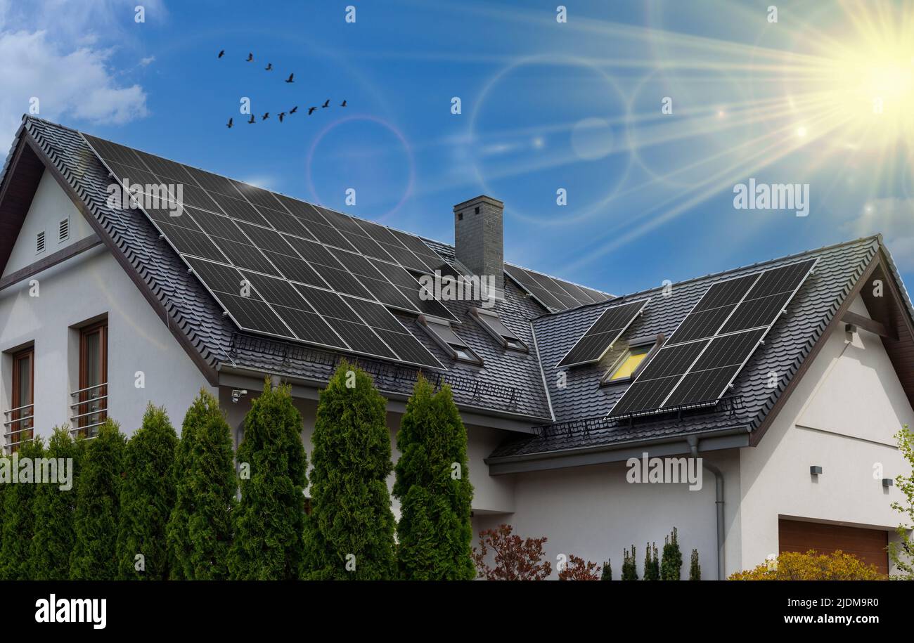 Black solar panels on gable roof. Beautiful, large modern house and ...