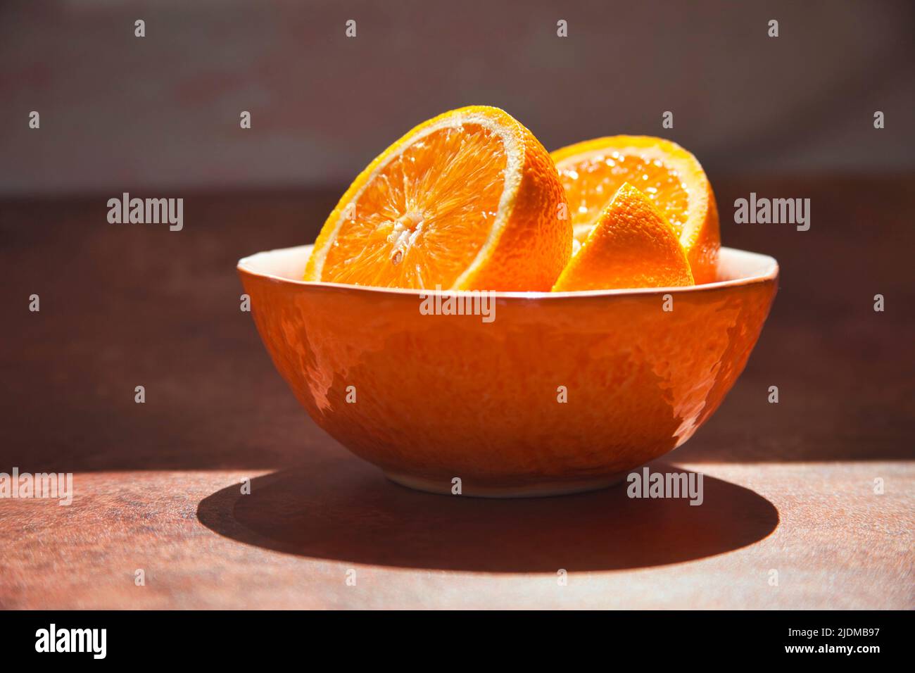 Orange Ceramic bowl of orange slices in sunlight Stock Photo - Alamy