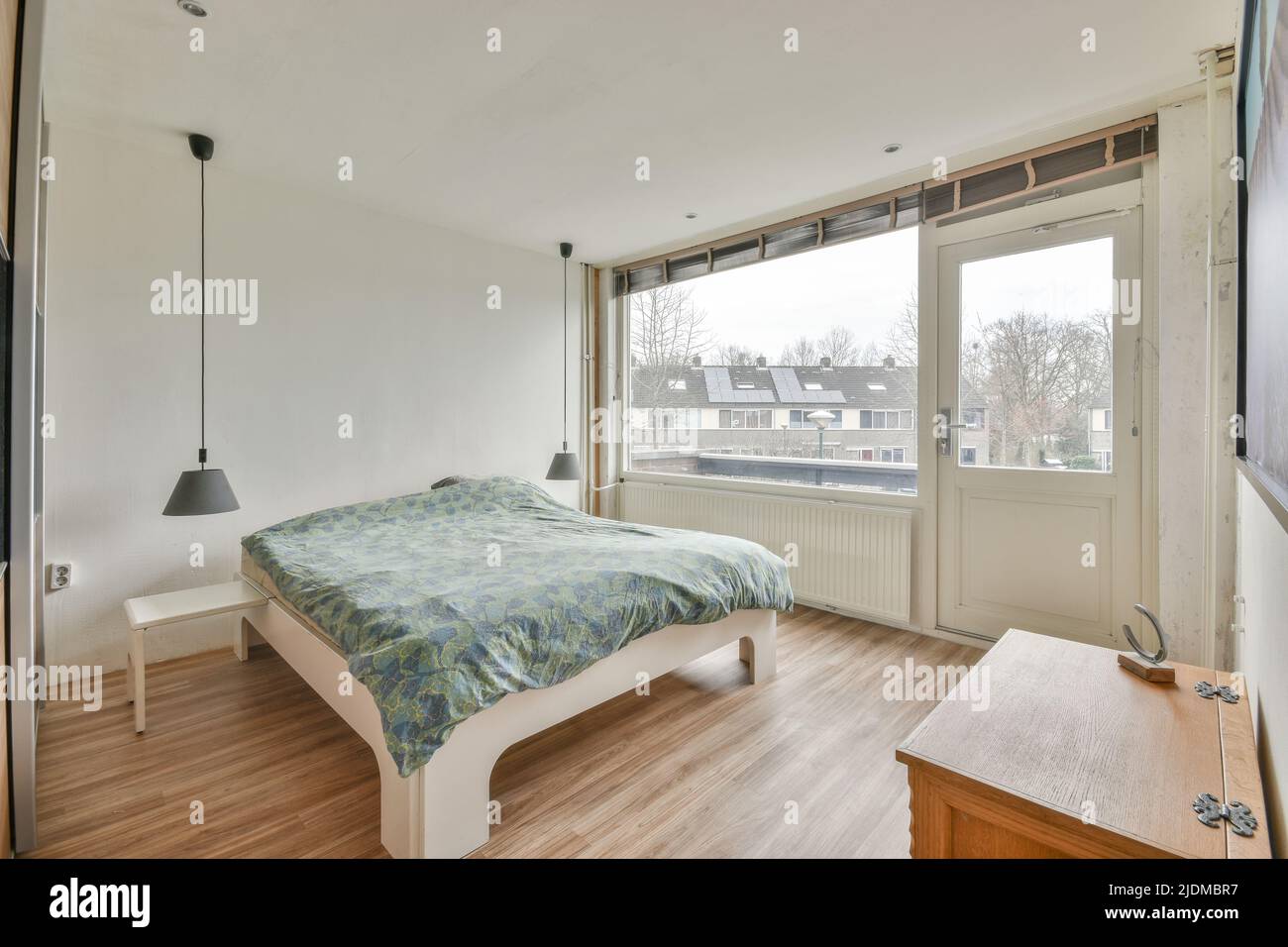 A spacious bright bedroom with a minimalistic bedside table and a large ...