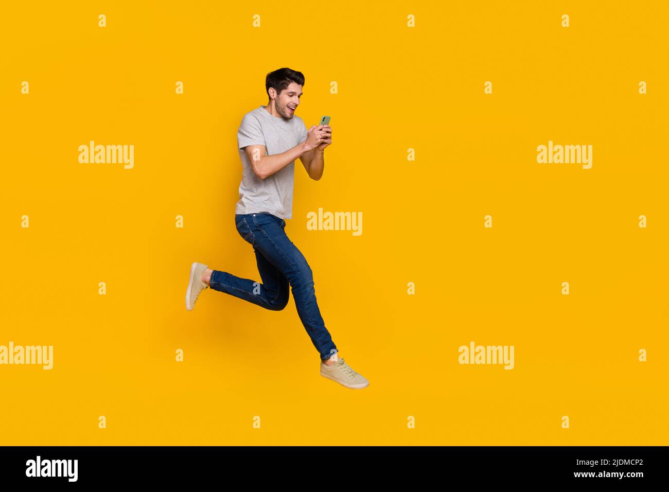 Full length body size view of attractive cheerful guy jumping using ...