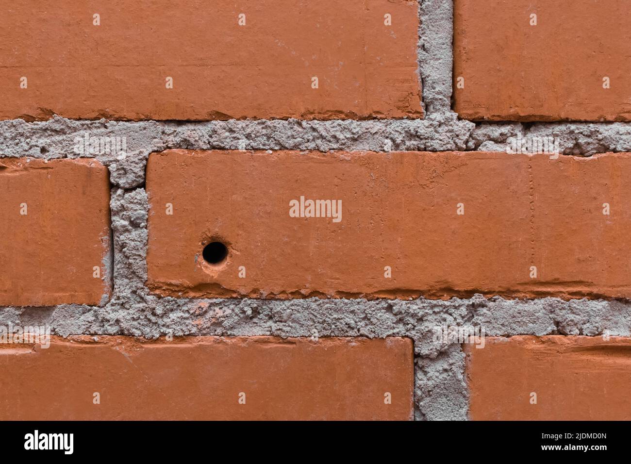 Drilled hole circle in brown brick wall close-up repair building ...