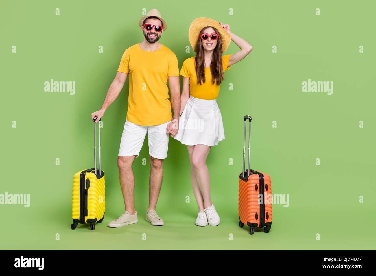 Full size photo of two idyllic cheerful partners hold hands suitcase ...