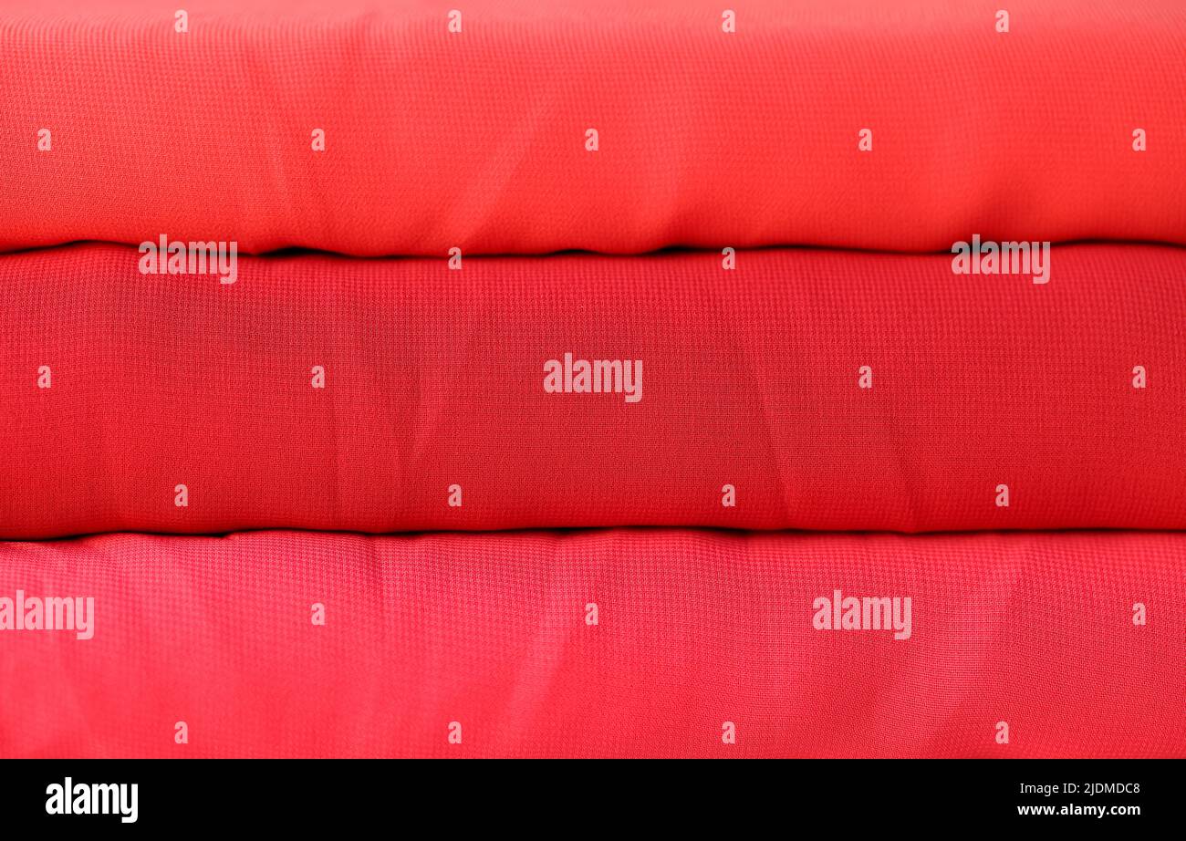 Red rolls of knitted fabric texture background Stock Photo - Alamy