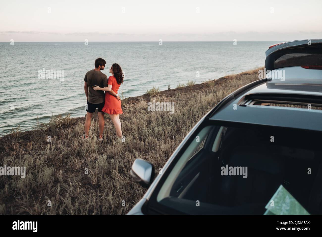 Young couple on car hugging hi-res stock photography and images - Alamy