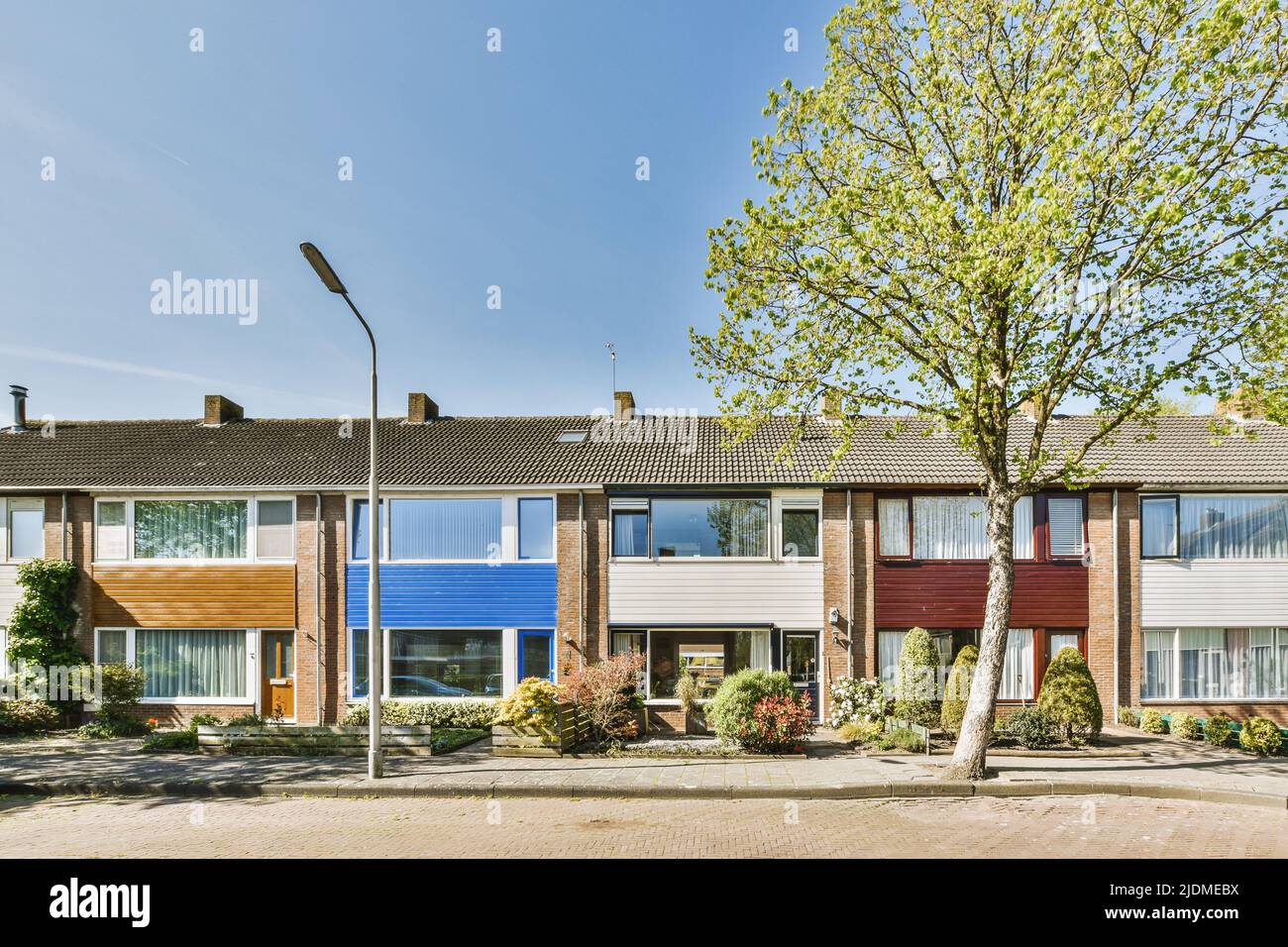 The front view of a brick building with signs, cars, pavement and ...