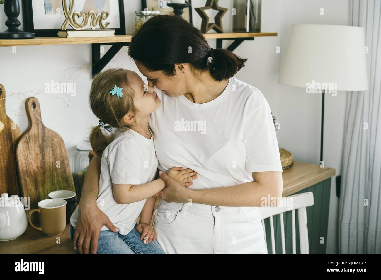 A mother gently hugs her four-year-old daughter Stock Photo - Alamy