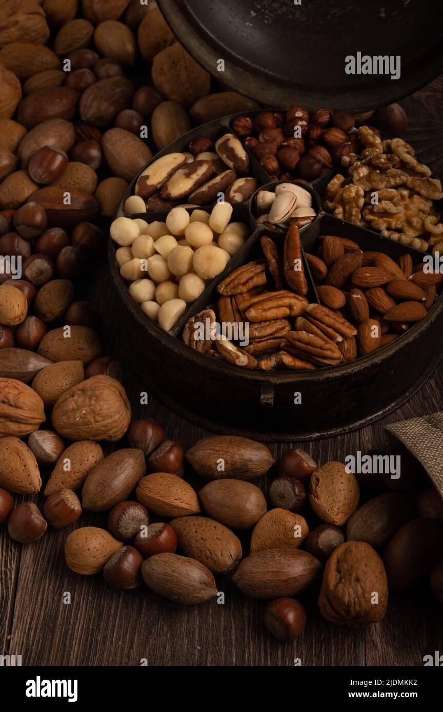 Mixed nuts in an old spice tin container and a hessian bag up close on ...