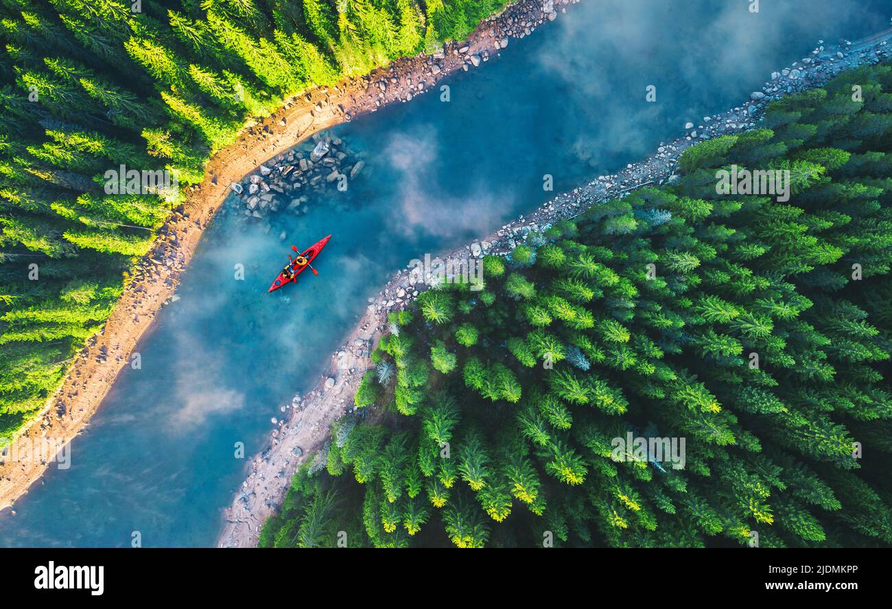 Aerial view of rafting boat or canoe in mountain river and forest ...