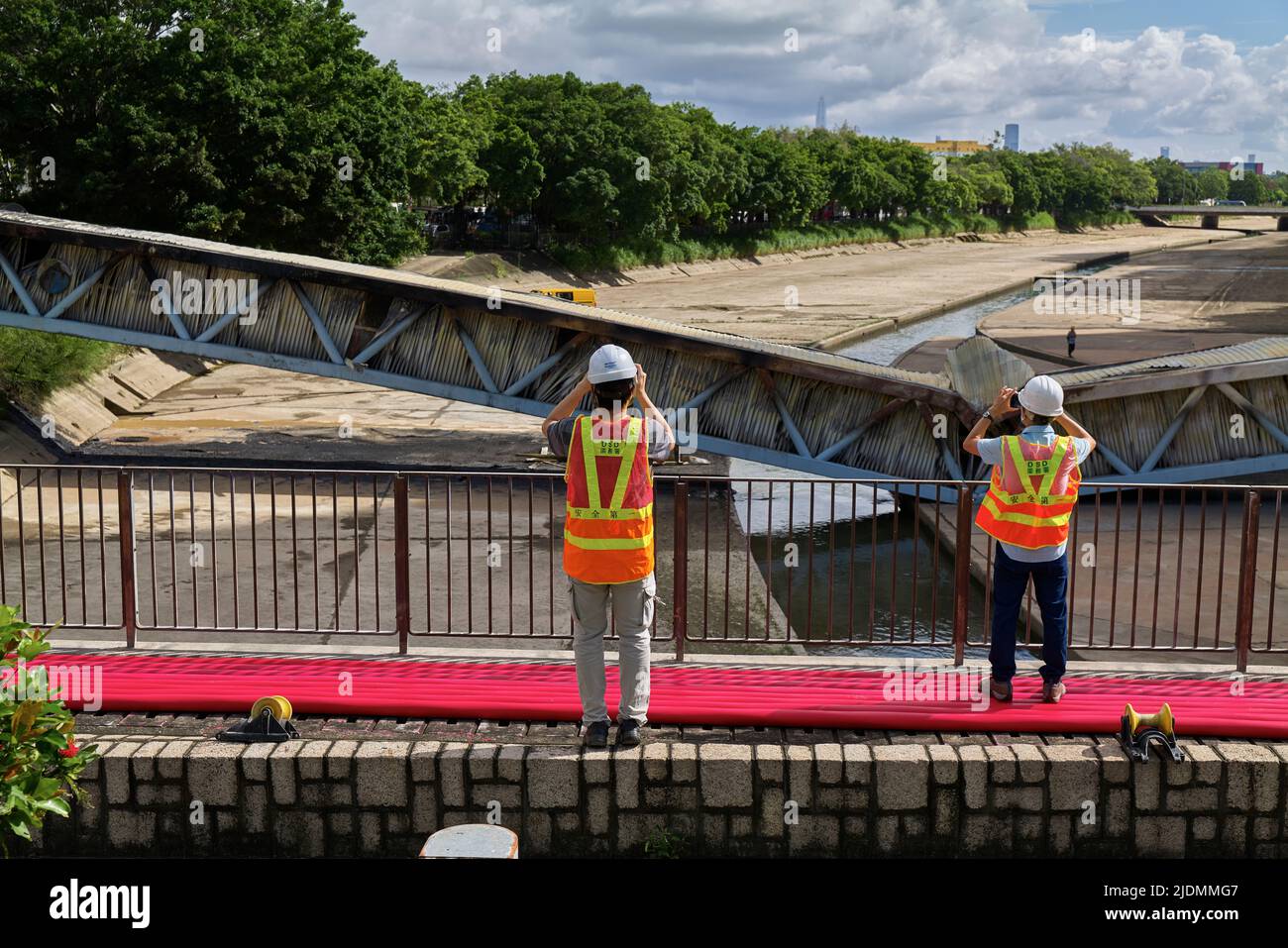 Workers take pictures of a bridge broken in two in Hong Kong following ...