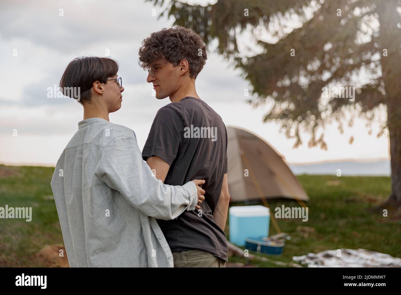Rear on Caucasian young couple standing in hugs and looking at each ...