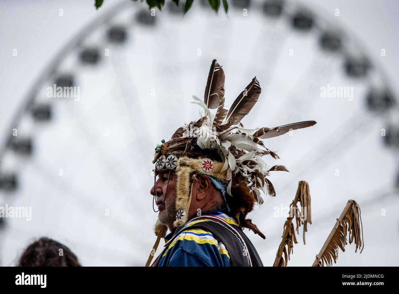 A Mohawk elder wearing his traditional feather headdress in front of La ...