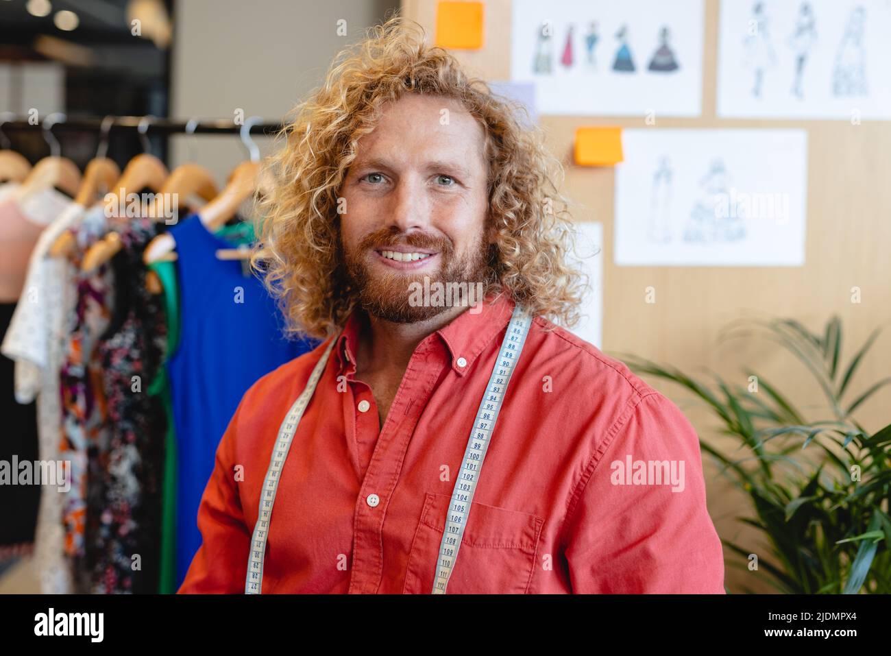 Portrait of smiling caucasian mid adult male fashion designer with long ...