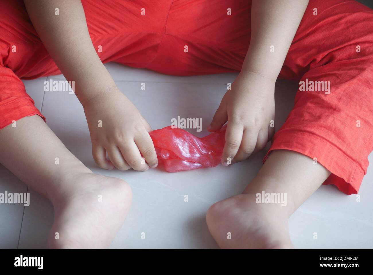 child Hand holding pink color slime Stock Photo - Alamy