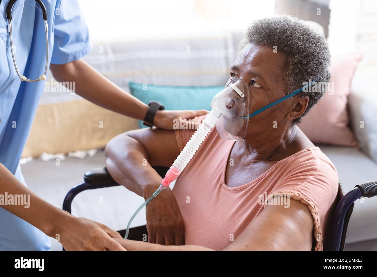 African american senior woman wearing oxygen mask looking at doctor ...