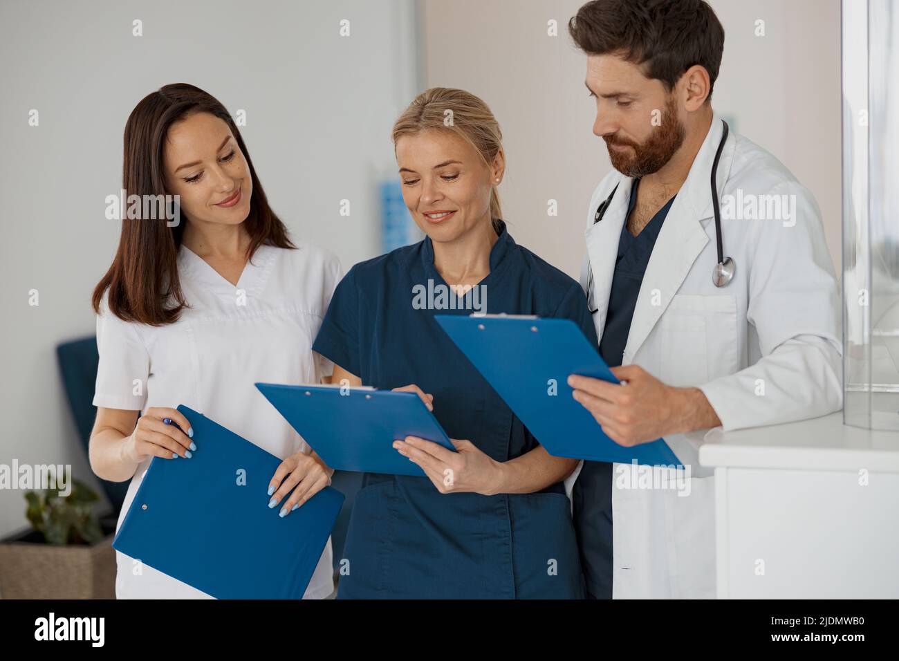 Group of doctor colleagues discussing patient diagnosis stand in clinic ...