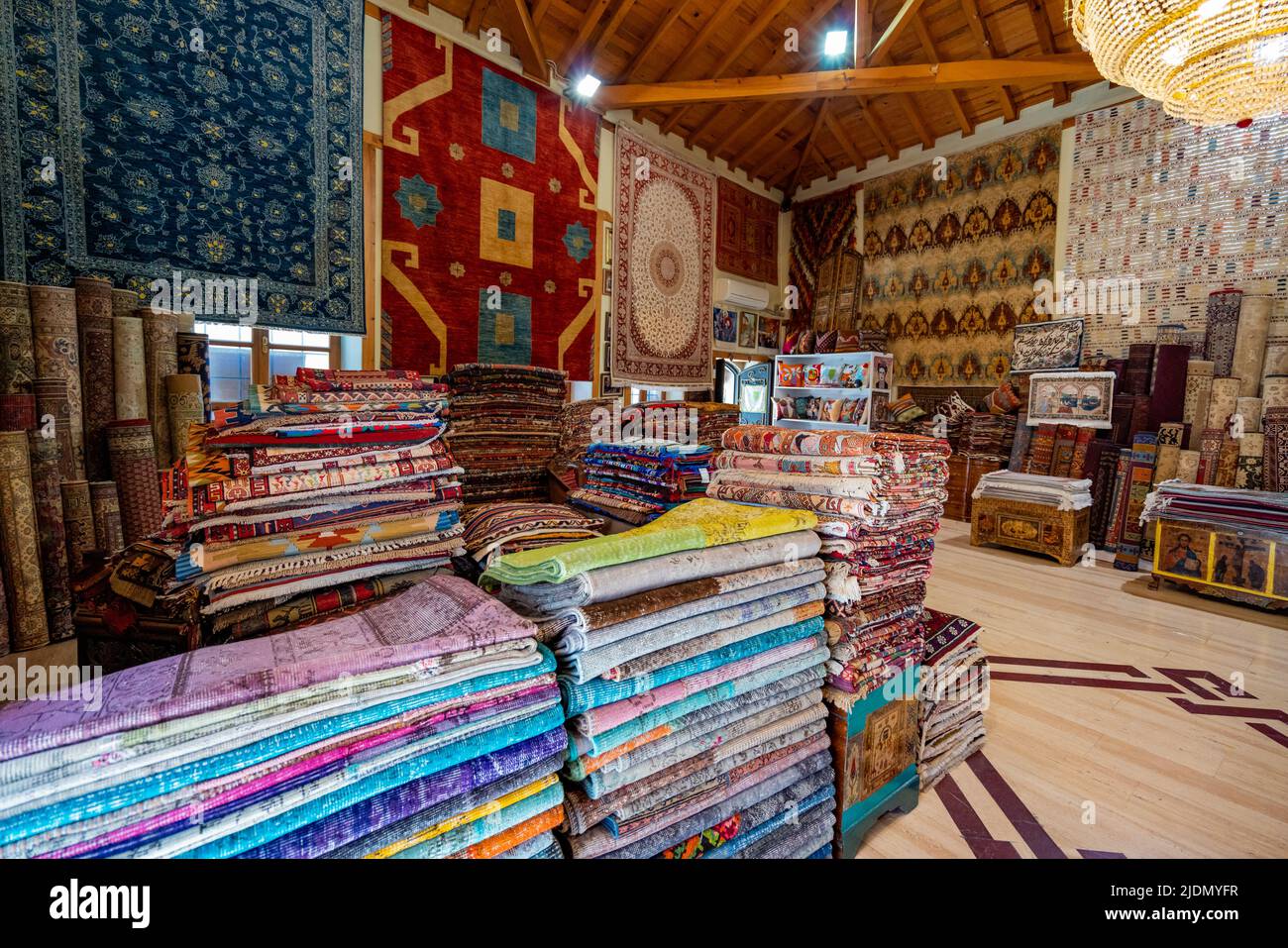 Large stacks of oriental rugs in a store. Colorful carpet market ...