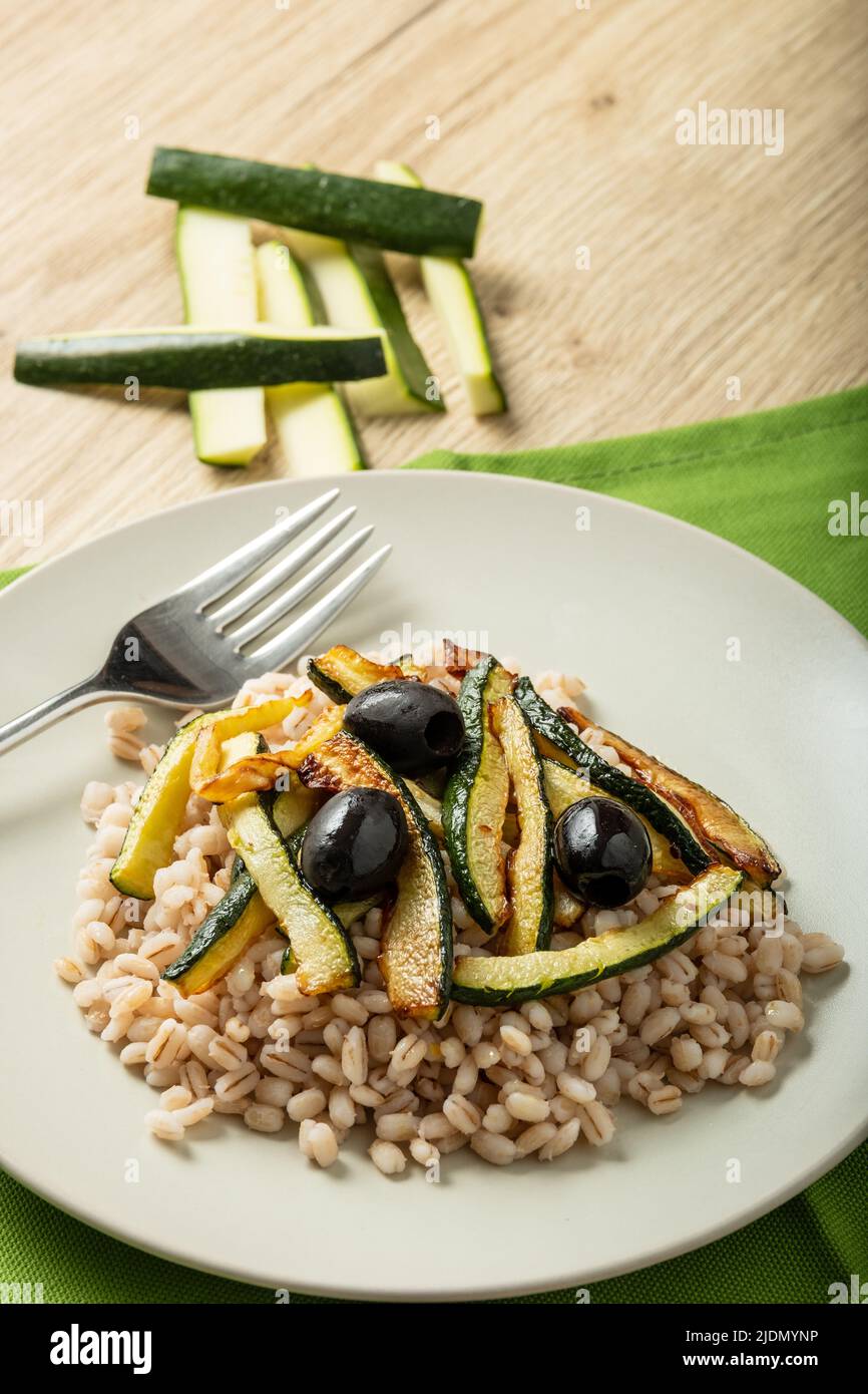 Pearl barley salad with zucchini, tuna and olives Stock Photo - Alamy
