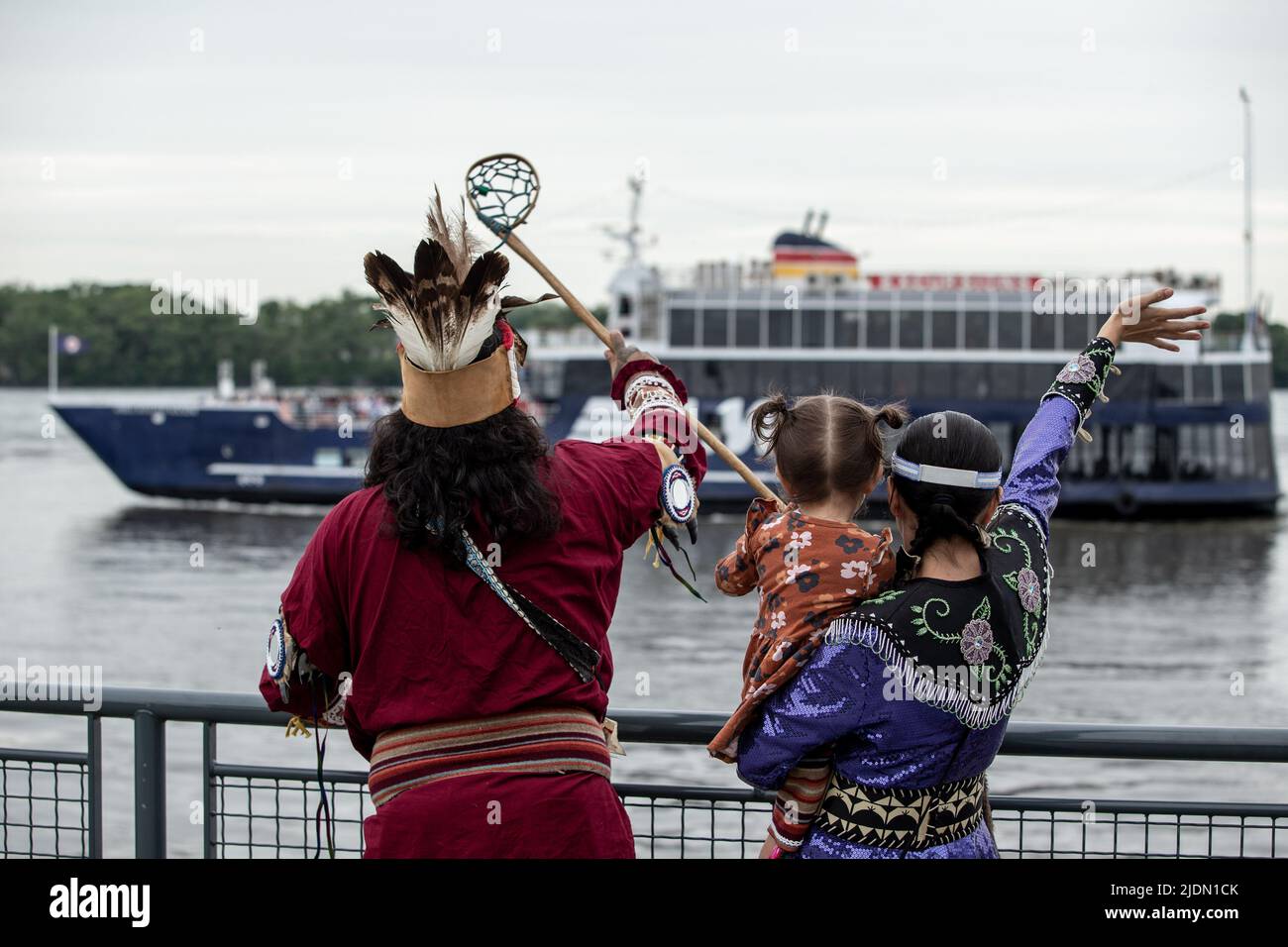 Two Indigenous dancers waving at a passing ship on the St. Lawrence ...