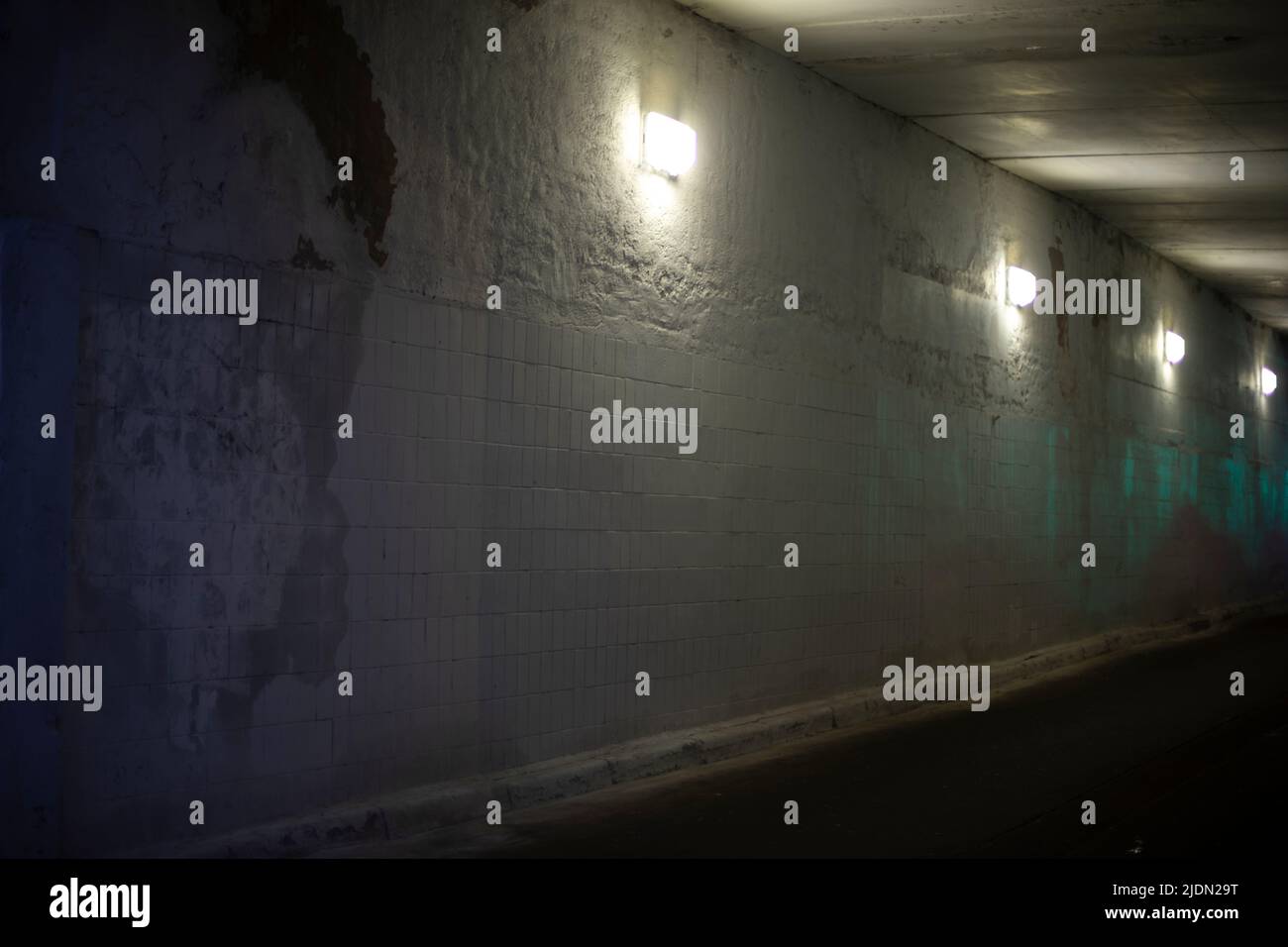 Wall at night is in light from lamps. Details of building at night ...